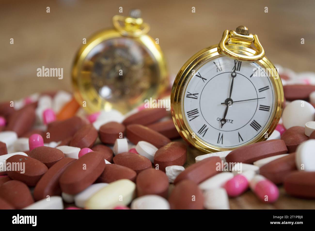 concept of time and health with a pile of pills and old pocket watch ...