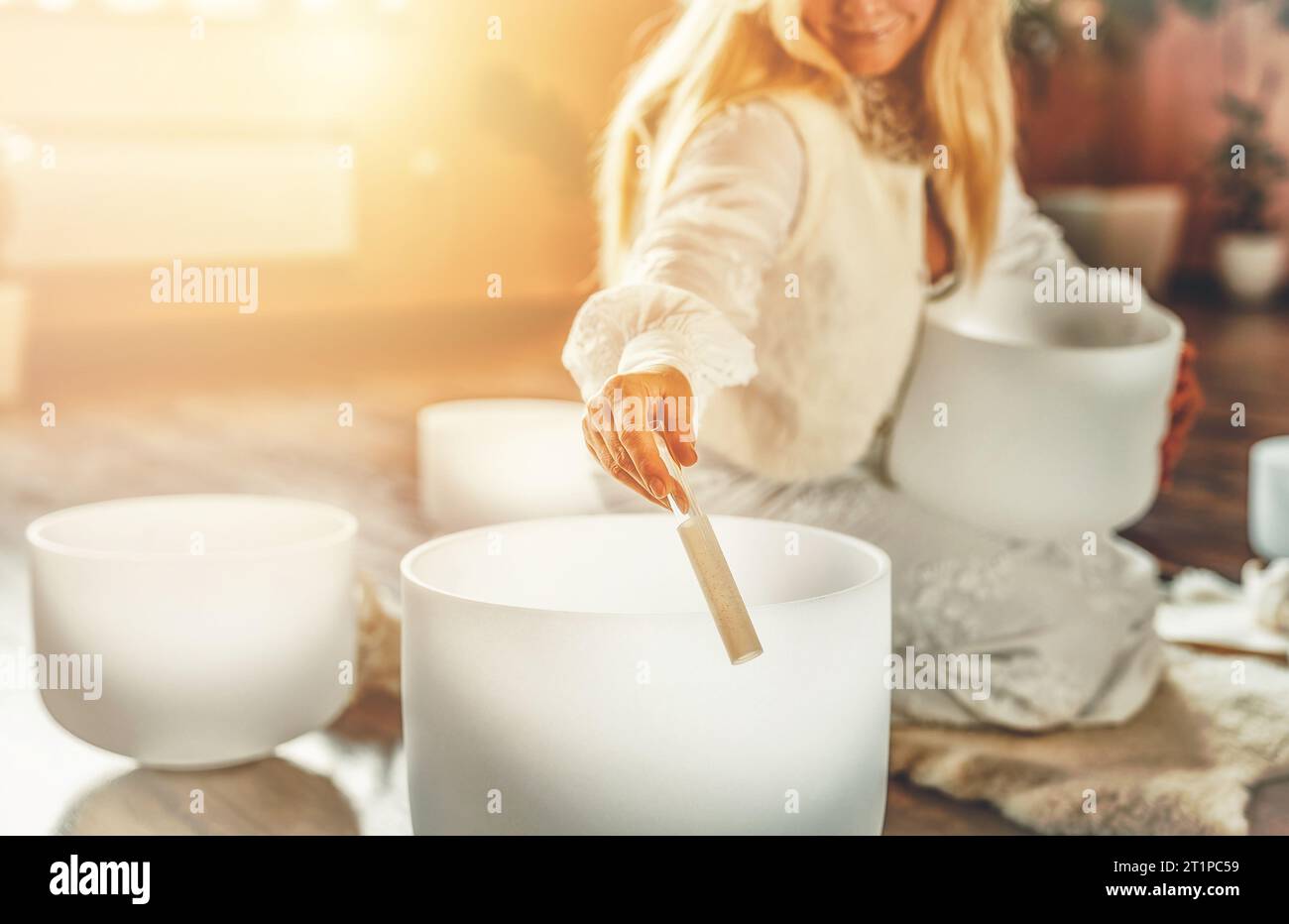 Woman playing on a crystal bowl. Ceremony space Stock Photo - Alamy