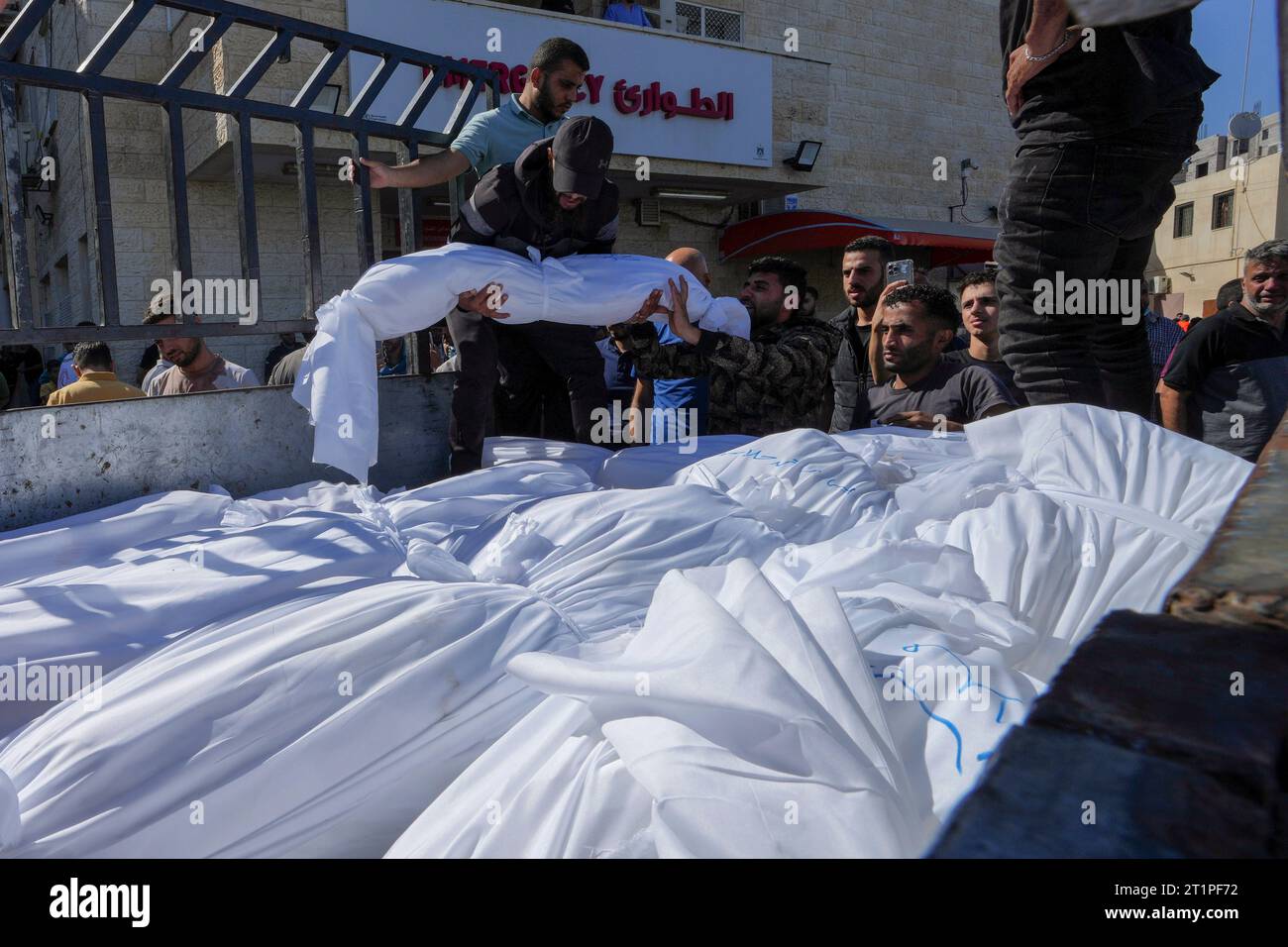 Sheet-covered bodies killed during an Israeli airstrike are loaded onto ...