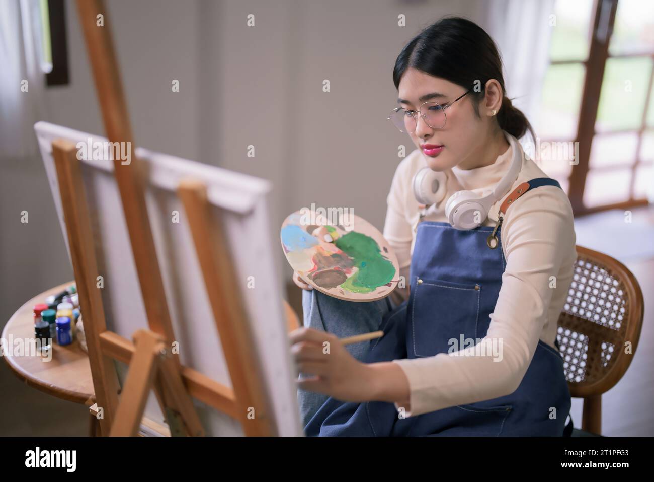 Young asian female artist use paintbrush and color to drawing and ...