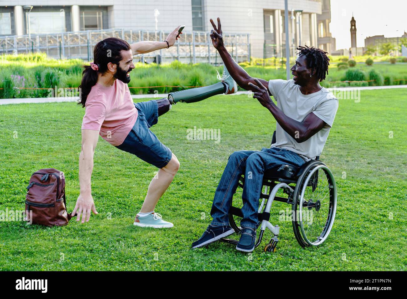 Two diverse friends outdoors: A man with a prosthetic leg playfully ...