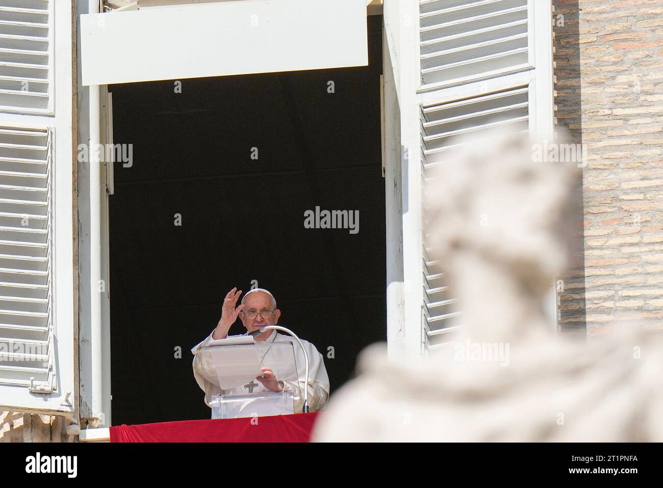 Pope Francis waves during the Angelus noon prayer from the window of ...