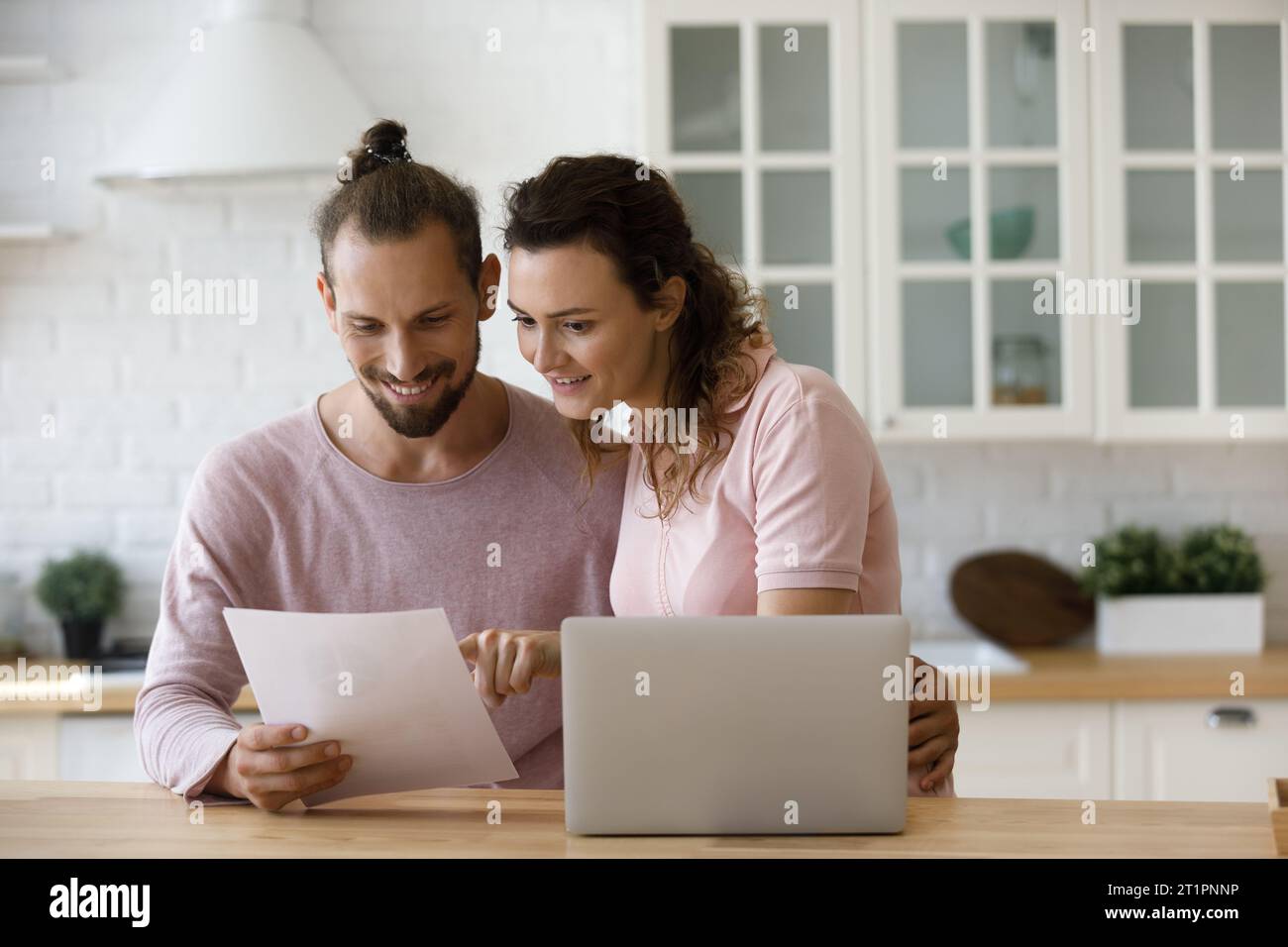 Happy satisfied millennial married couple reading paper document at ...