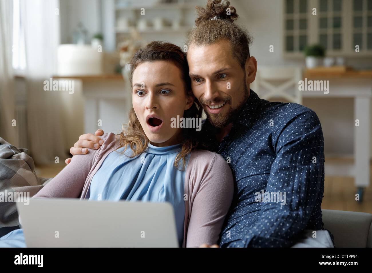 Shocked happy couple getting email message with surprising good news ...