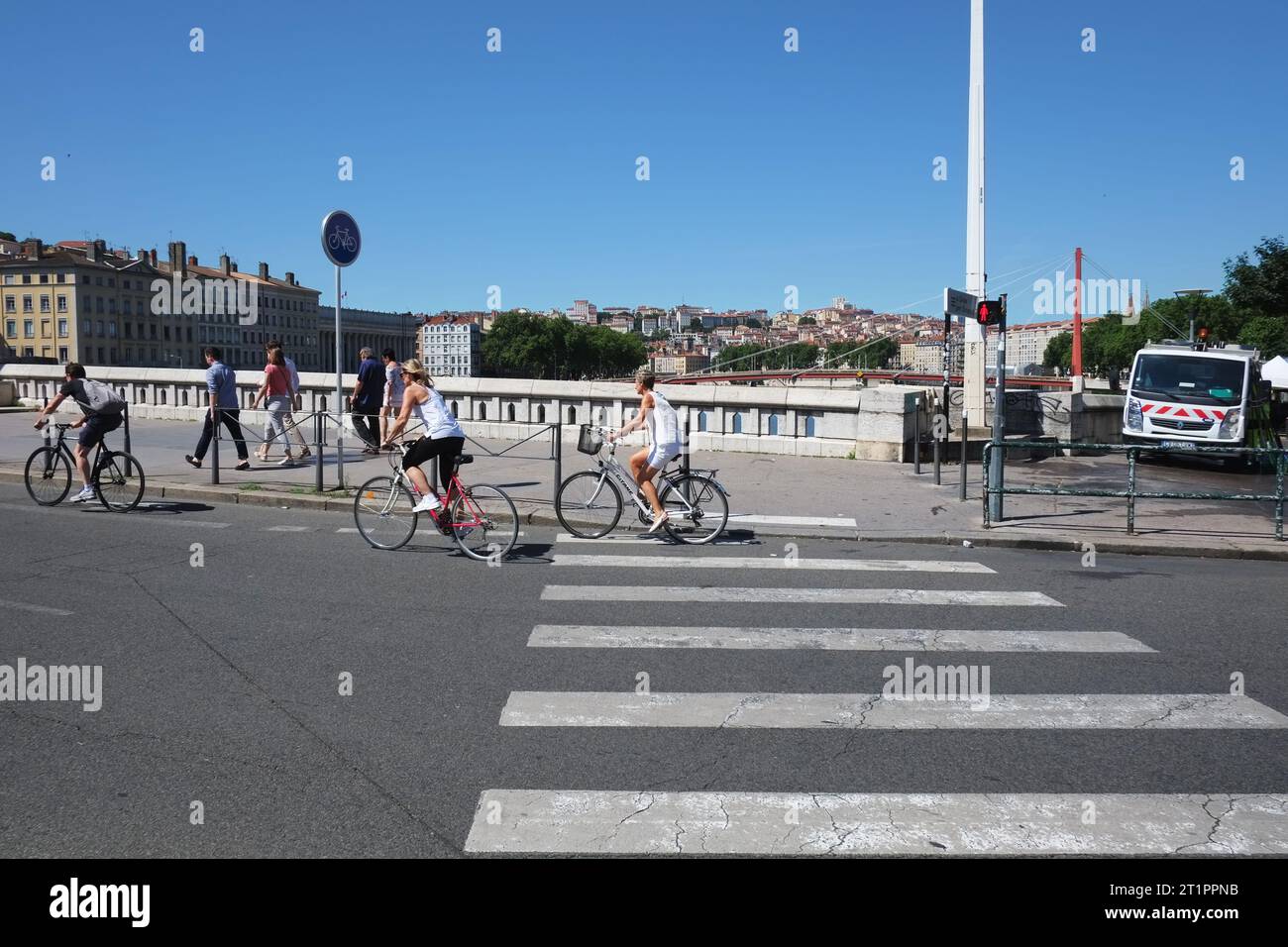 Cyclists ride past a zebra crossing at Pont Bonaparte in Lyon, France ...