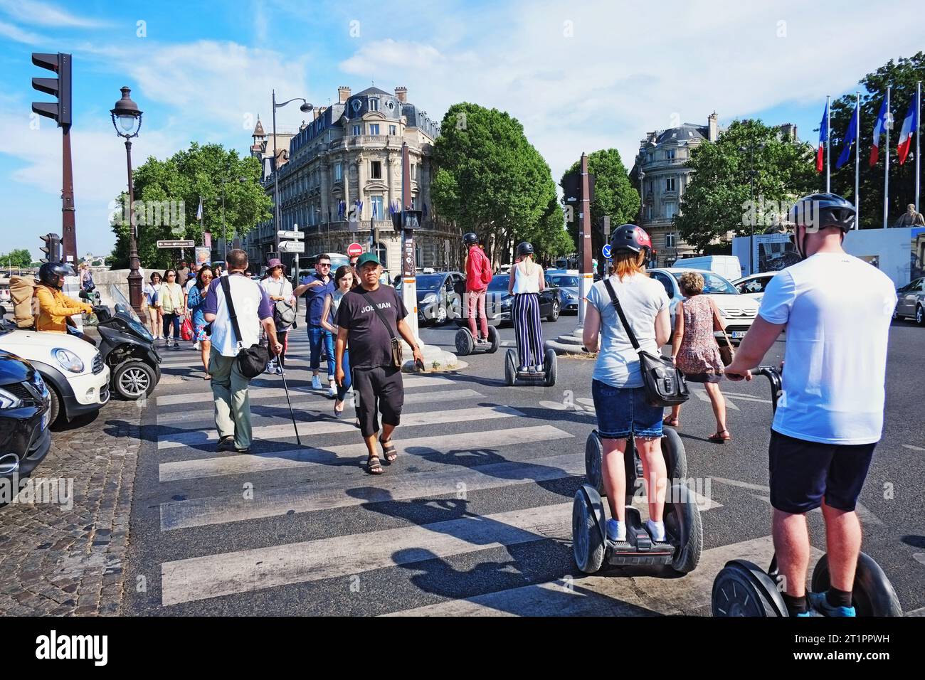 A busy zebra crossing in Paris with a Paris Segway tour and pedestrians ...