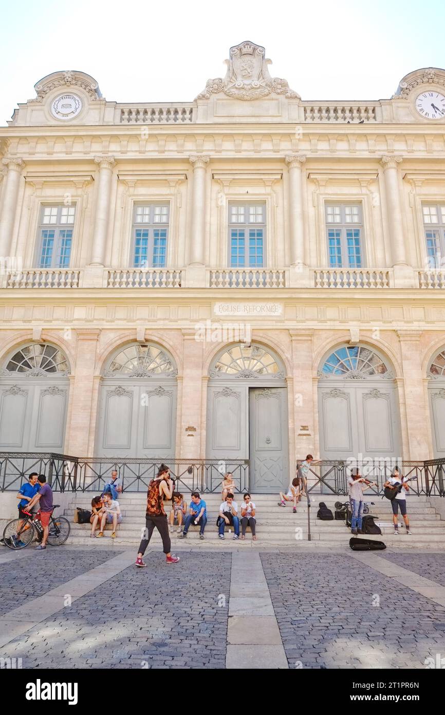 People enjoying buskers playing on a warm sunny day, sitting on the ...