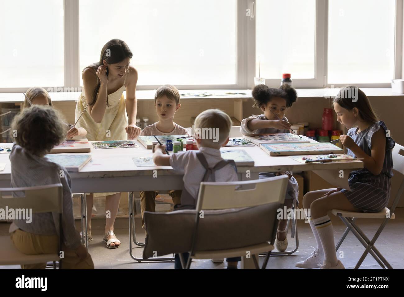 Children take part in art-class led by young female artist Stock Photo ...