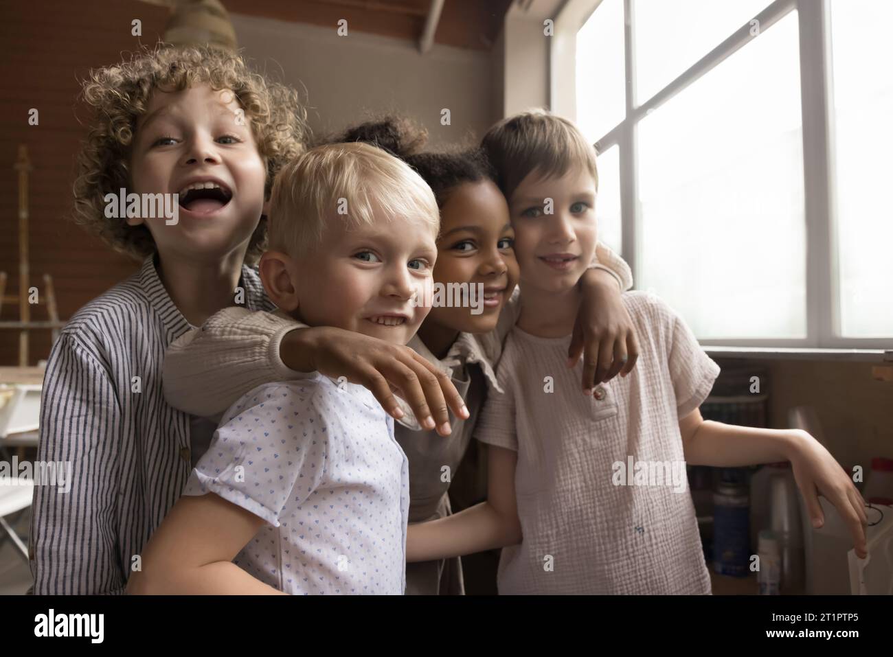 Four multiethnic children laughing staring at camera Stock Photo - Alamy