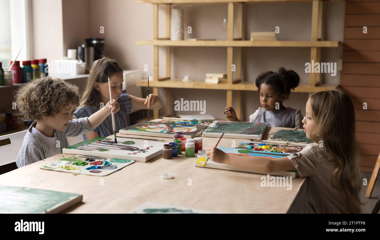 Group of little children painting pictures with paints on canvas Stock ...