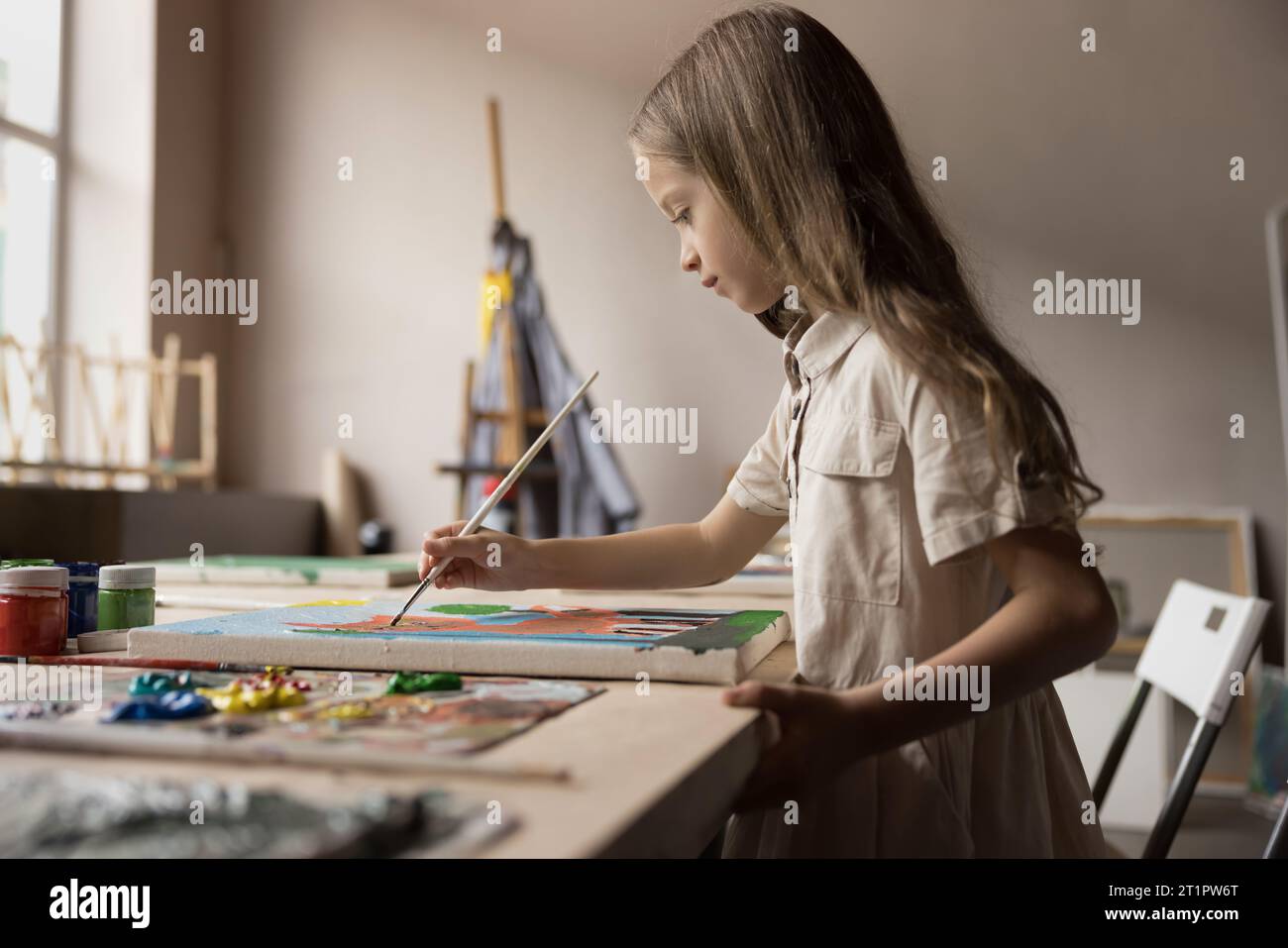 Serious concentrated girl painting on canvas with acrylic paints Stock ...