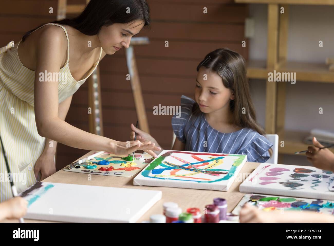Artist woman teaching little girl during art class in studio Stock ...