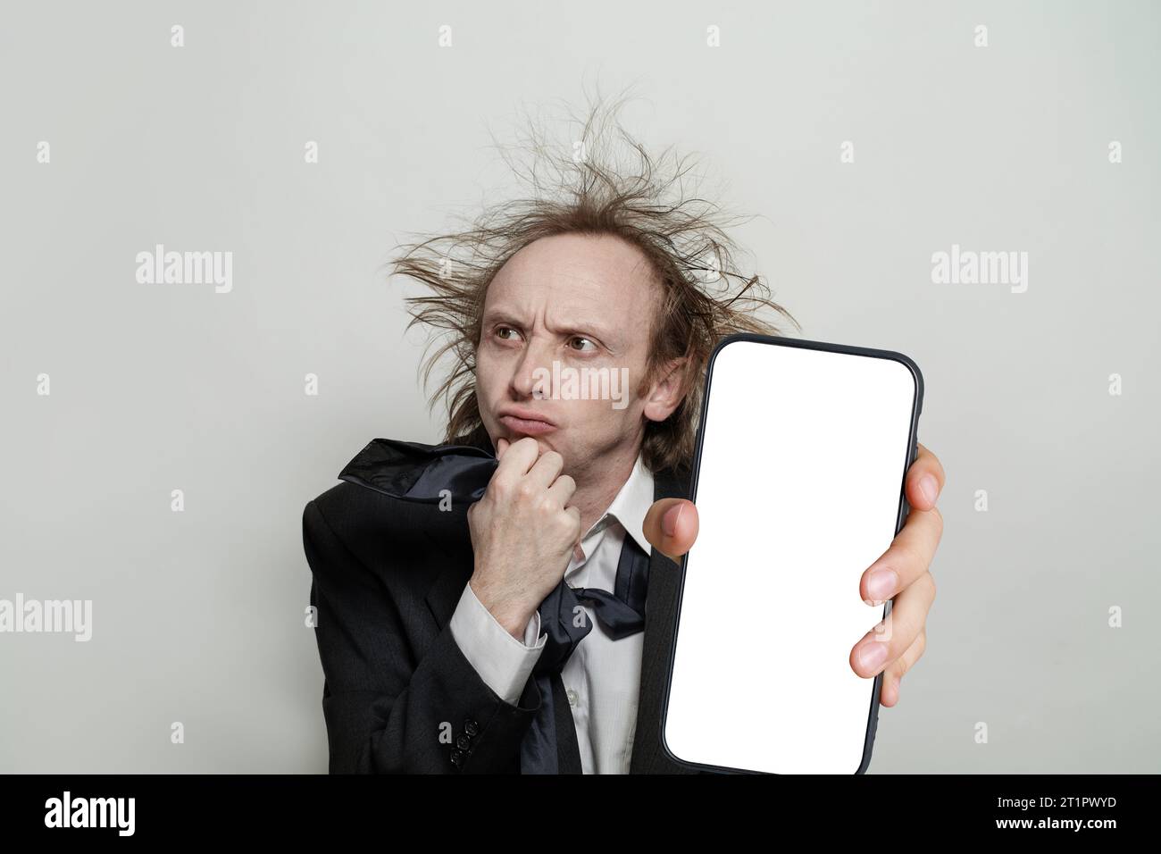 Thinking businessman holding smartphone with blank empty white screen ...