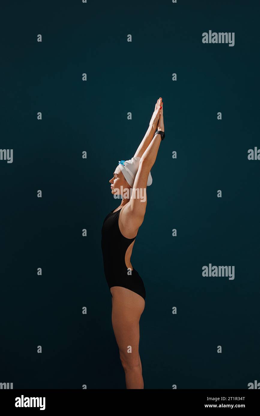 Side view of a young slim female swimmer preparing for competition ...