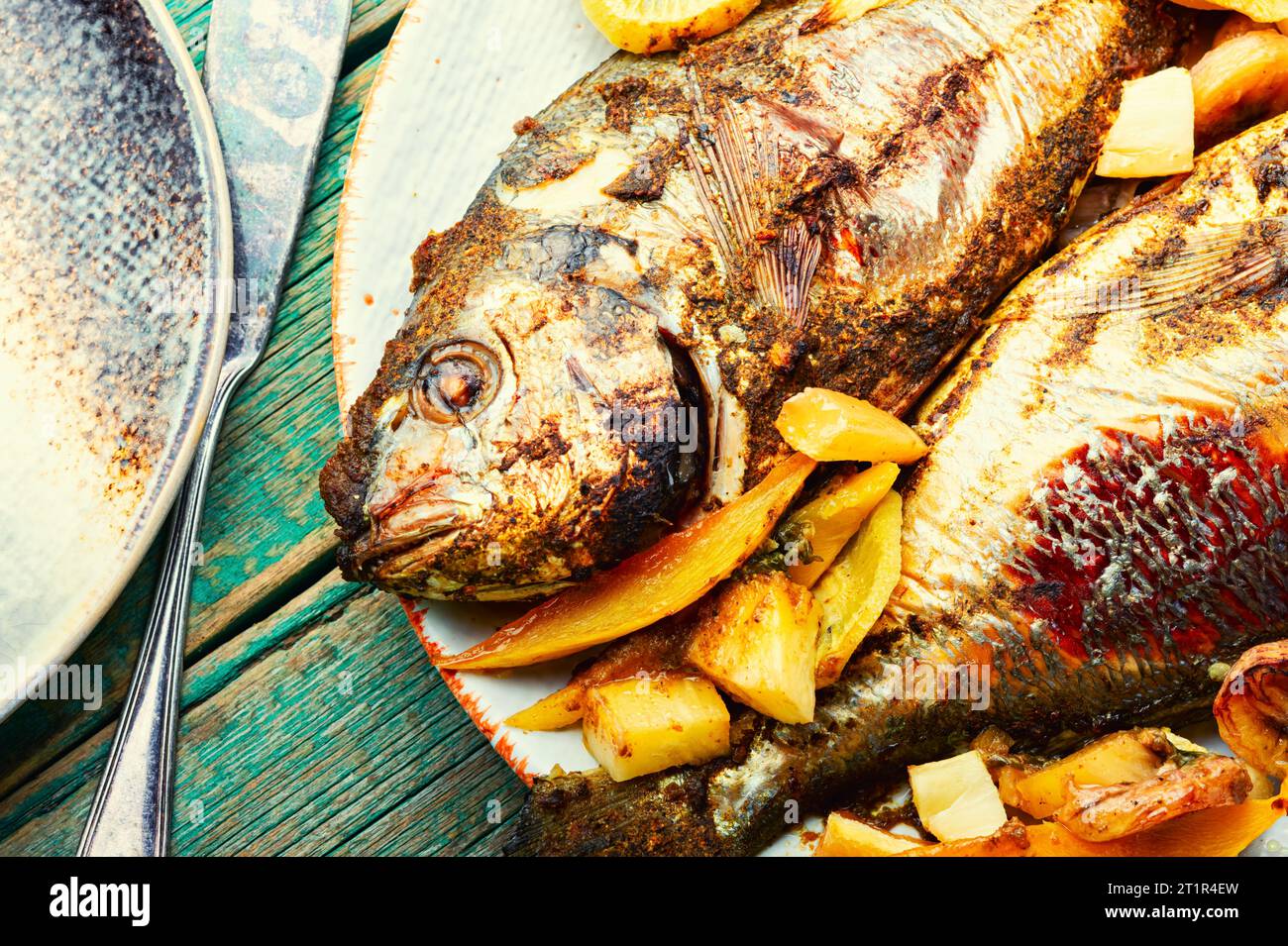 Delicious fried fish dorada with fruits and spices Stock Photo - Alamy