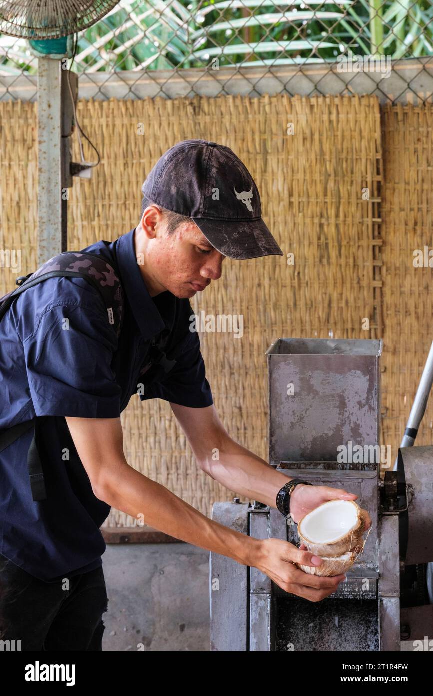 Man Demonstrating Opening a Coconut, at a Mekong River Coconut Candy ...