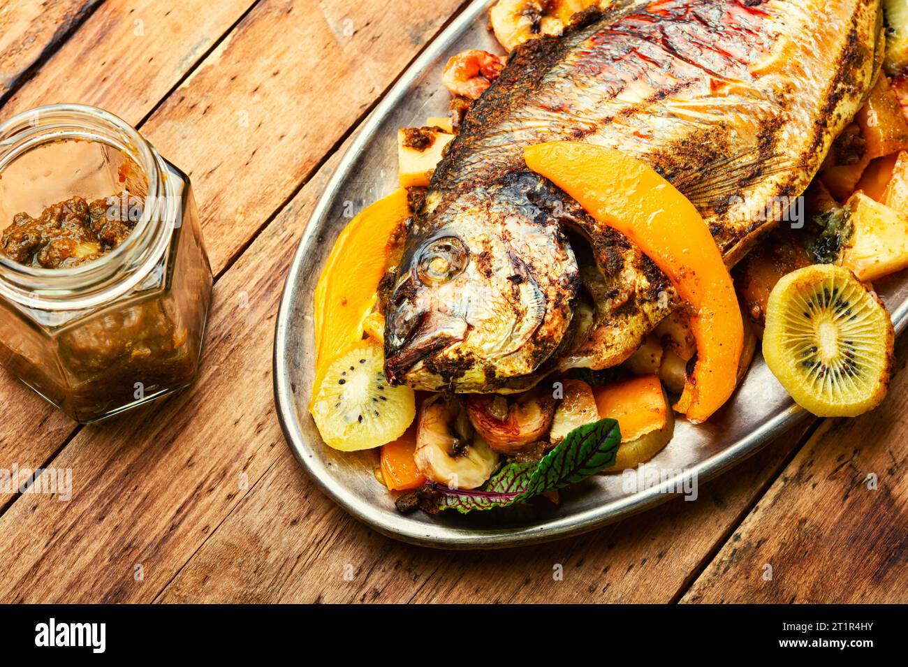 Delicious fried fish dorada with fruits and spices Stock Photo - Alamy