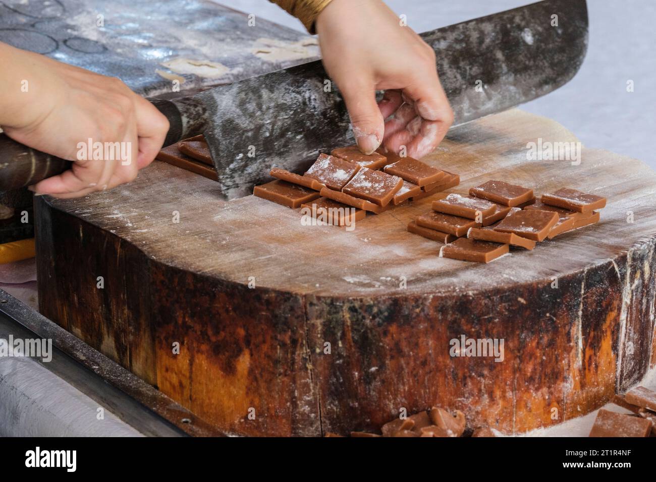 Cutting Coconut Candy Strips into Pieces for Wrapping at a Coconut ...