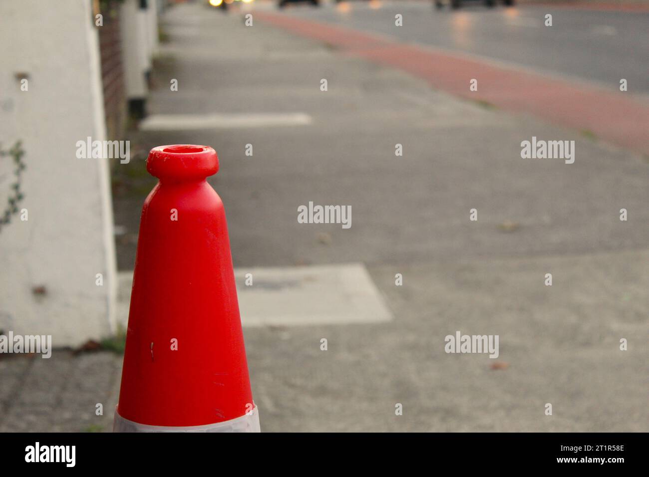 A photo of the top of an orange traffic cone on a path Stock Photo - Alamy
