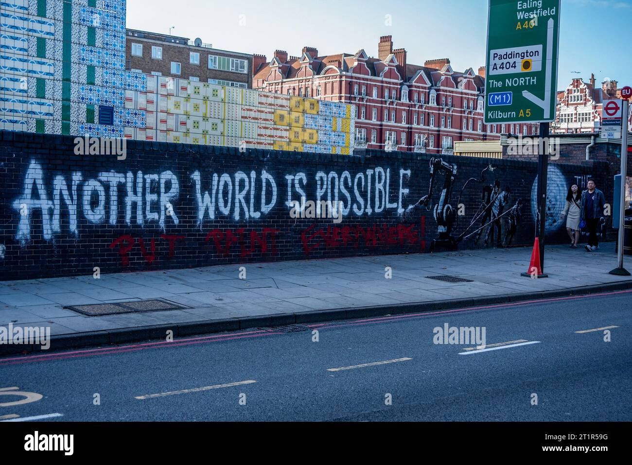 London, UK. 14th Oct, 2023. A couple walks by the potential new Banksy ...