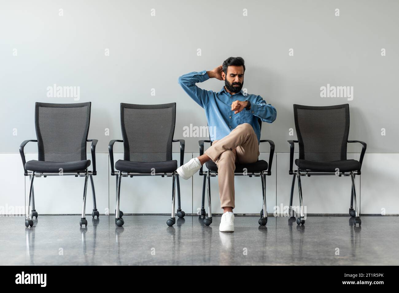 Worried indian job seeker waiting for interview far too long, sitting ...