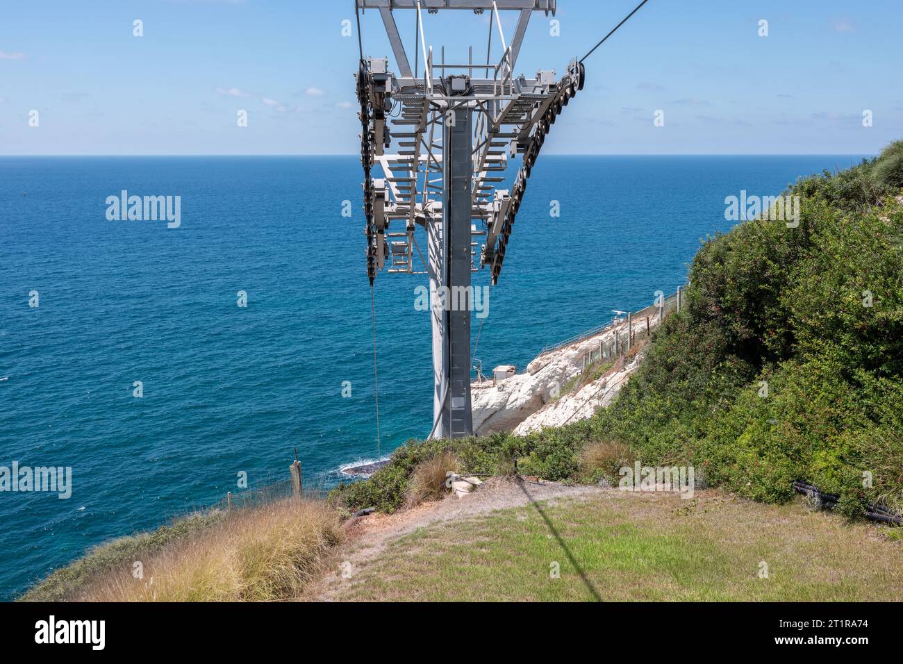 Funicular cables up the mountain. Blue sea and sky in the background ...