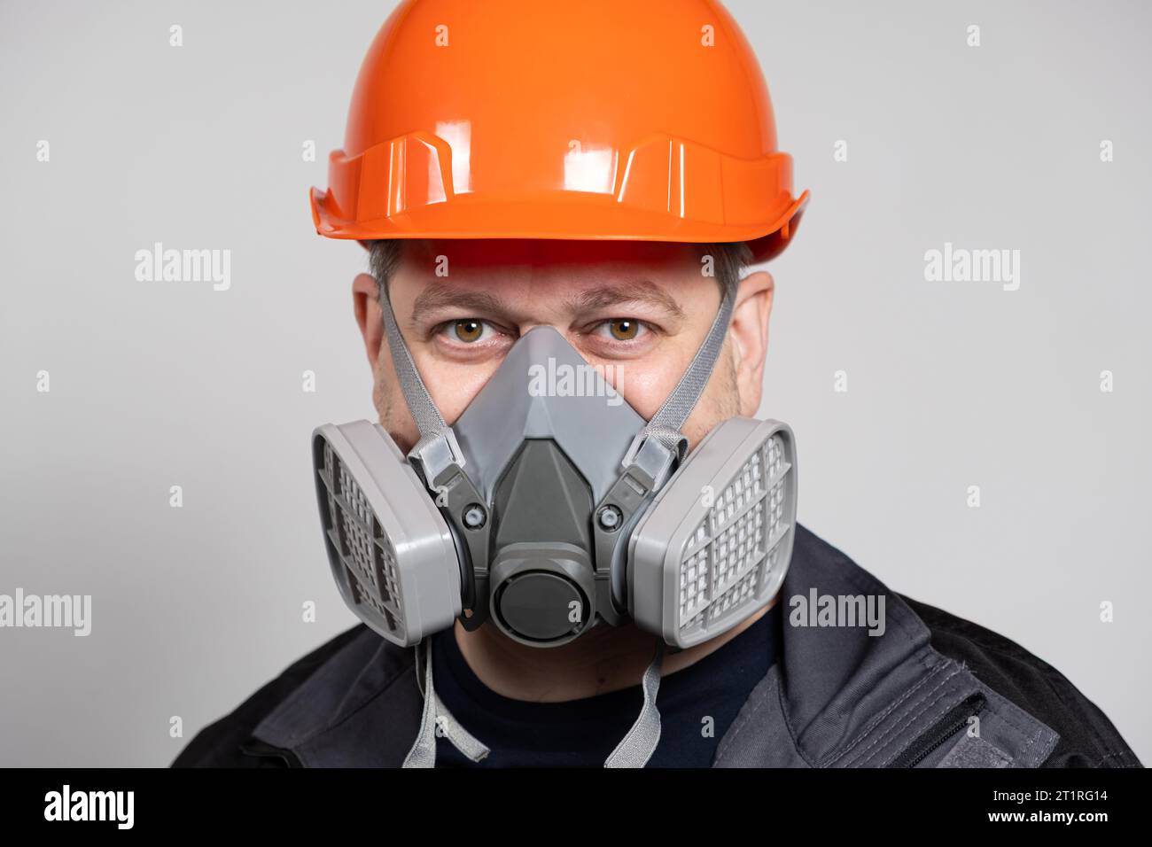A man wearing a safety helmet and a respirator to protect against dust ...