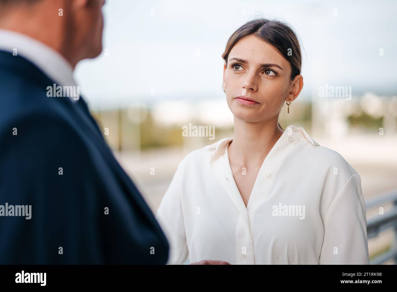 A woman wearing a yellow dress has her arm around the neck of a man ...