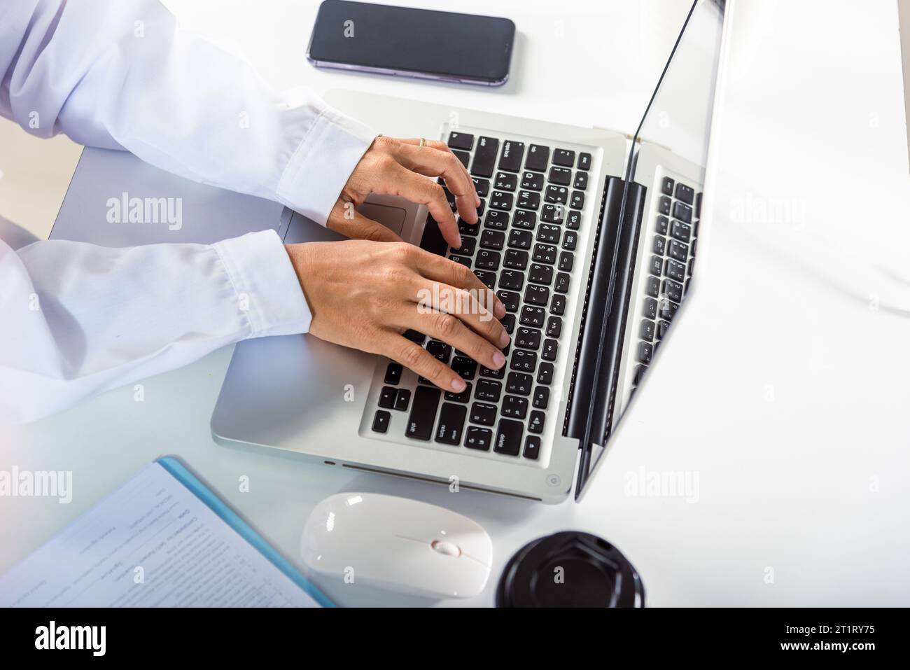 Hands of female doctor wear uniform in hospital she typing information ...