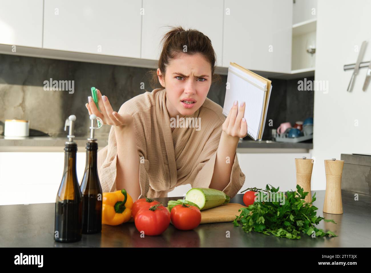 Portrait of woman cant cook, looking confused while making meal ...