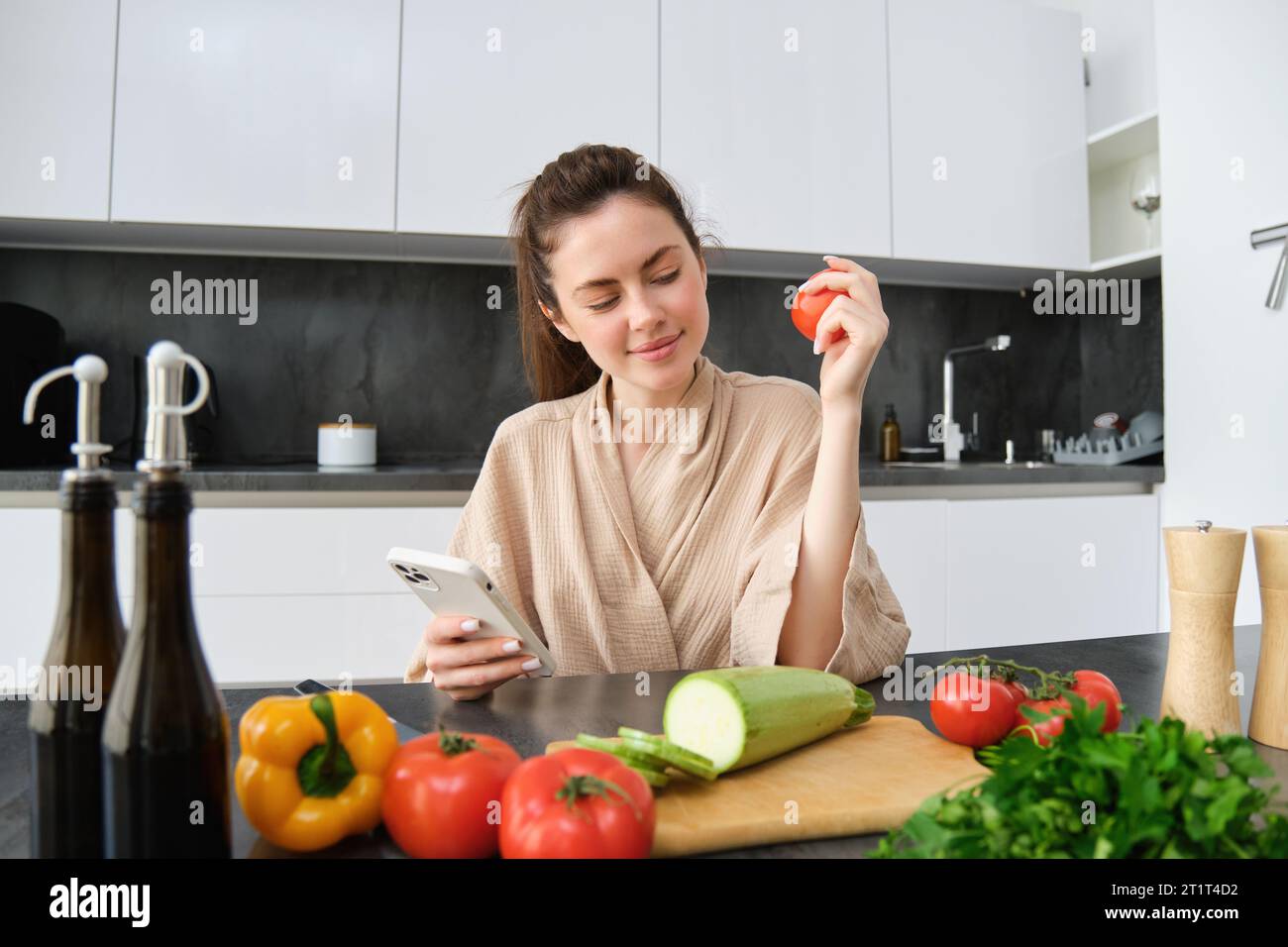 Image of young woman, chef on kitchen, cooking dinner at home, sitting ...