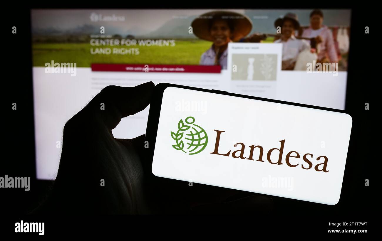 Person holding mobile phone with logo of American organization Landesa ...