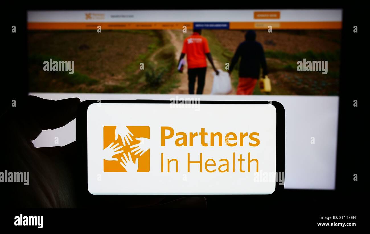 Person holding mobile phone with logo of American organization Partners ...