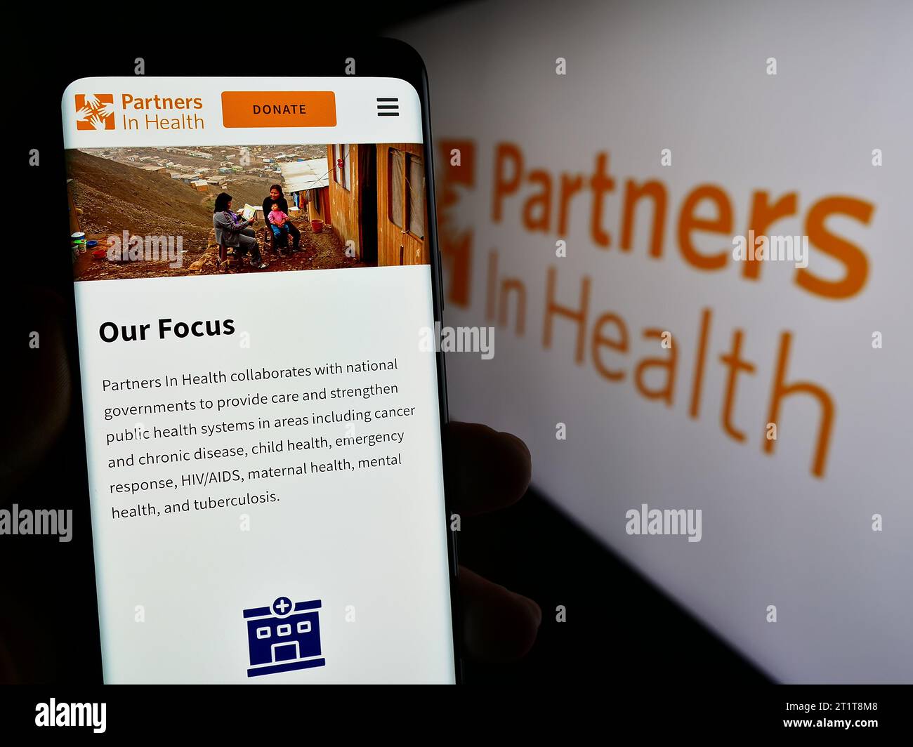 Person holding smartphone with web page of US organization Partners In ...
