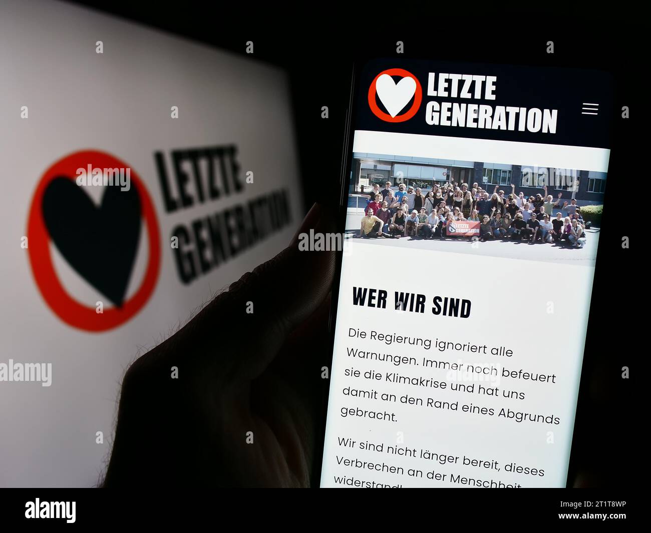 Person holding cellphone with website of climate change activist group ...