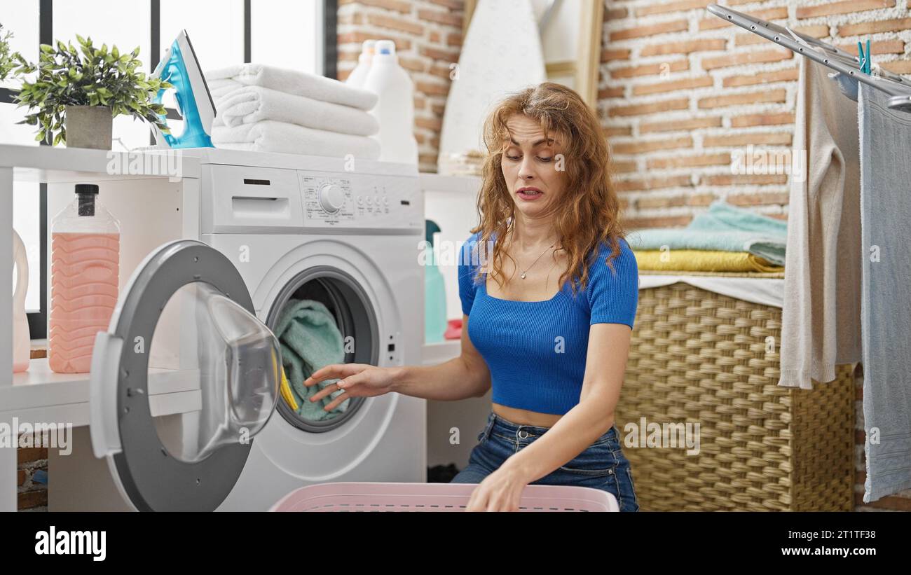 Young woman washing clothes at laundry room Stock Photo - Alamy