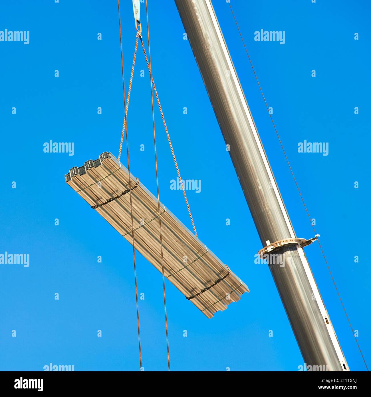 Crane lifting building construction material Stock Photo - Alamy