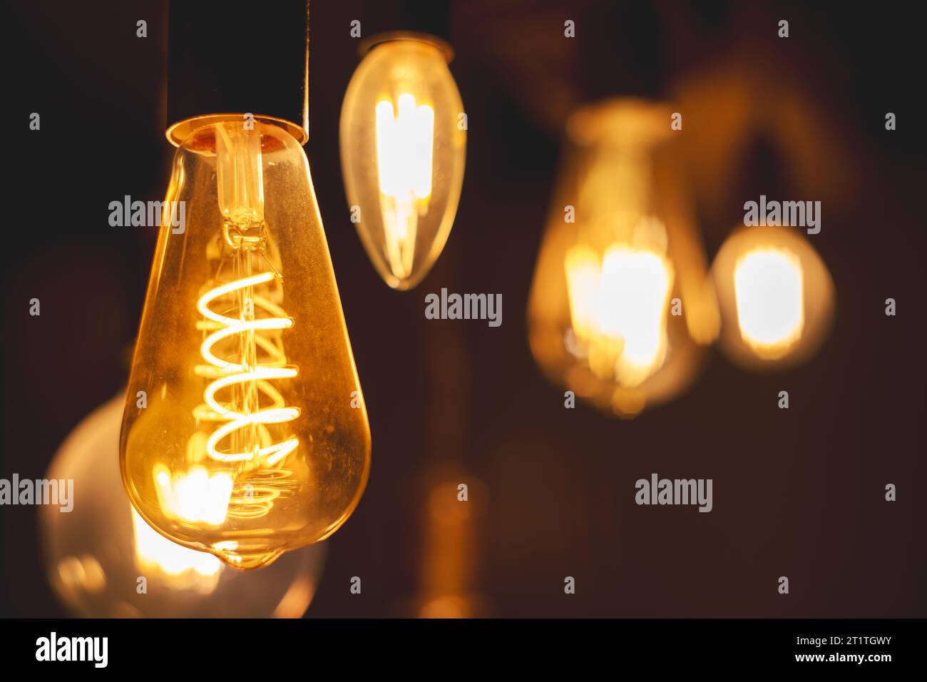 Spiral Retro LED light bulbs hanging on a dark background in interior ...