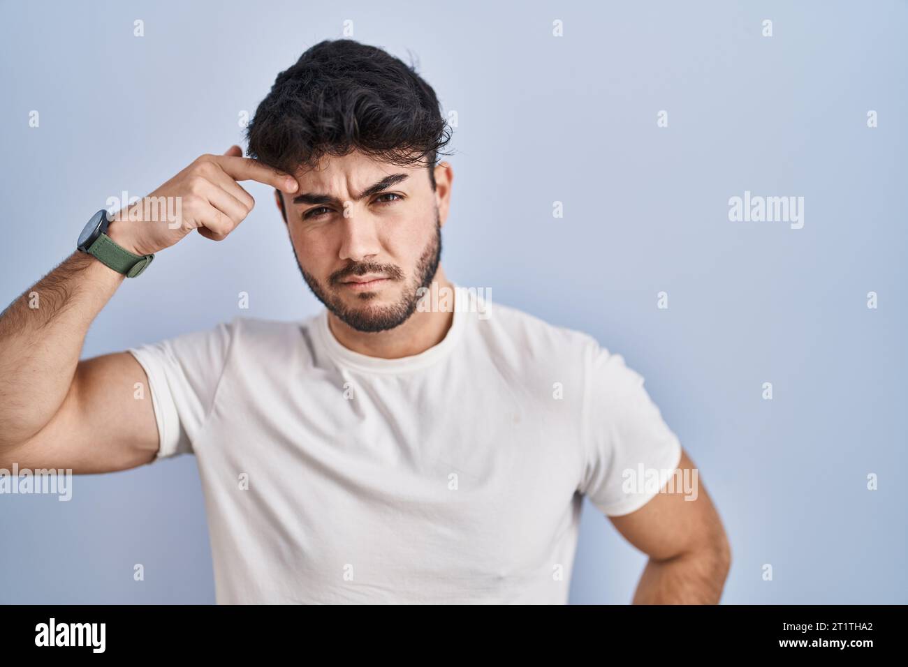 Hispanic man with beard standing over white background pointing unhappy ...
