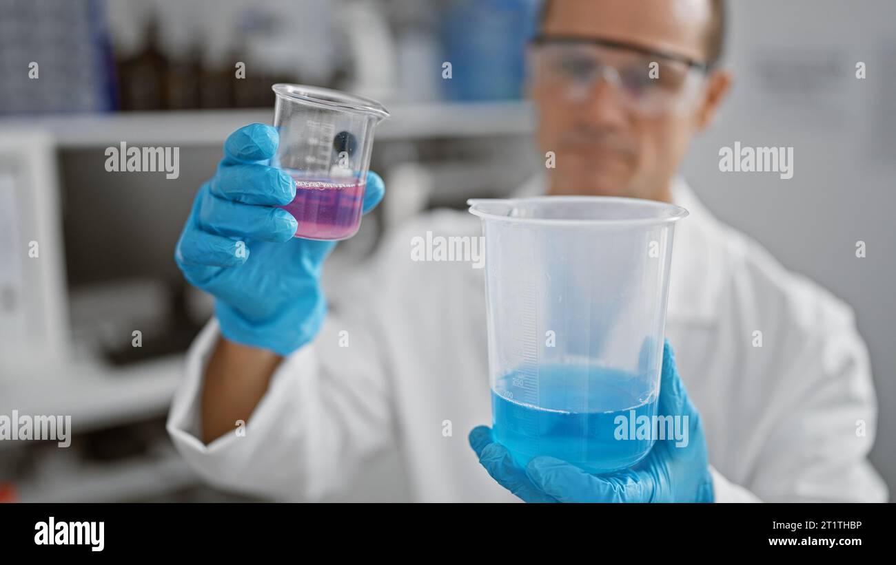 Middle age man scientist measuring liquid at laboratory Stock Photo - Alamy