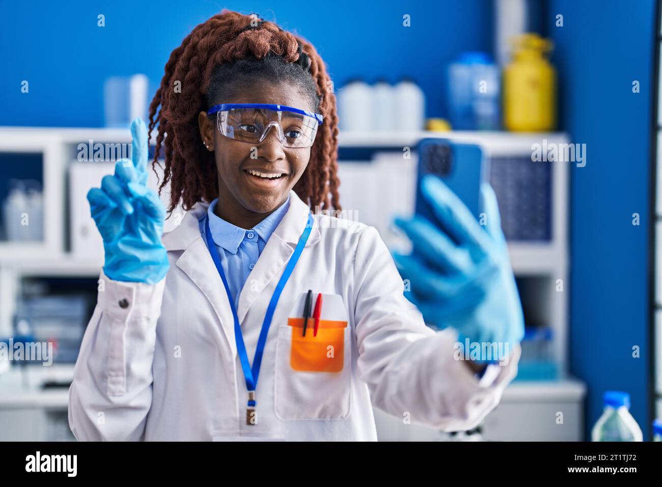 African woman working at scientist laboratory doing video call smiling ...
