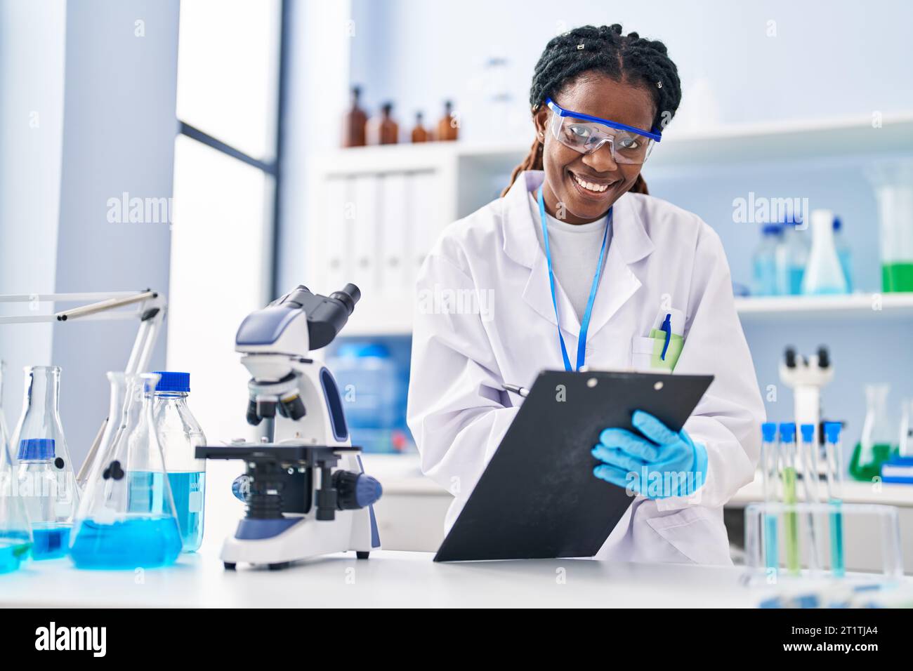 African american woman scientist writing report working at laboratory Stock Photo - Alamy