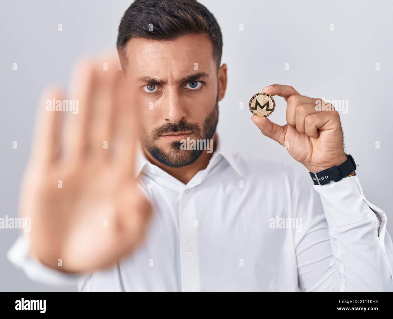 Handsome hispanic man holding monero cryptocurrency coin with open hand ...