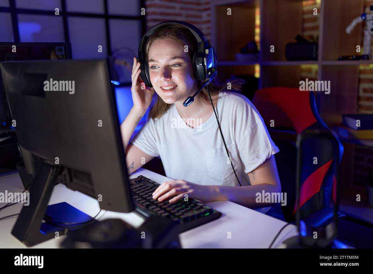 Young caucasian woman streamer playing video game using computer at ...