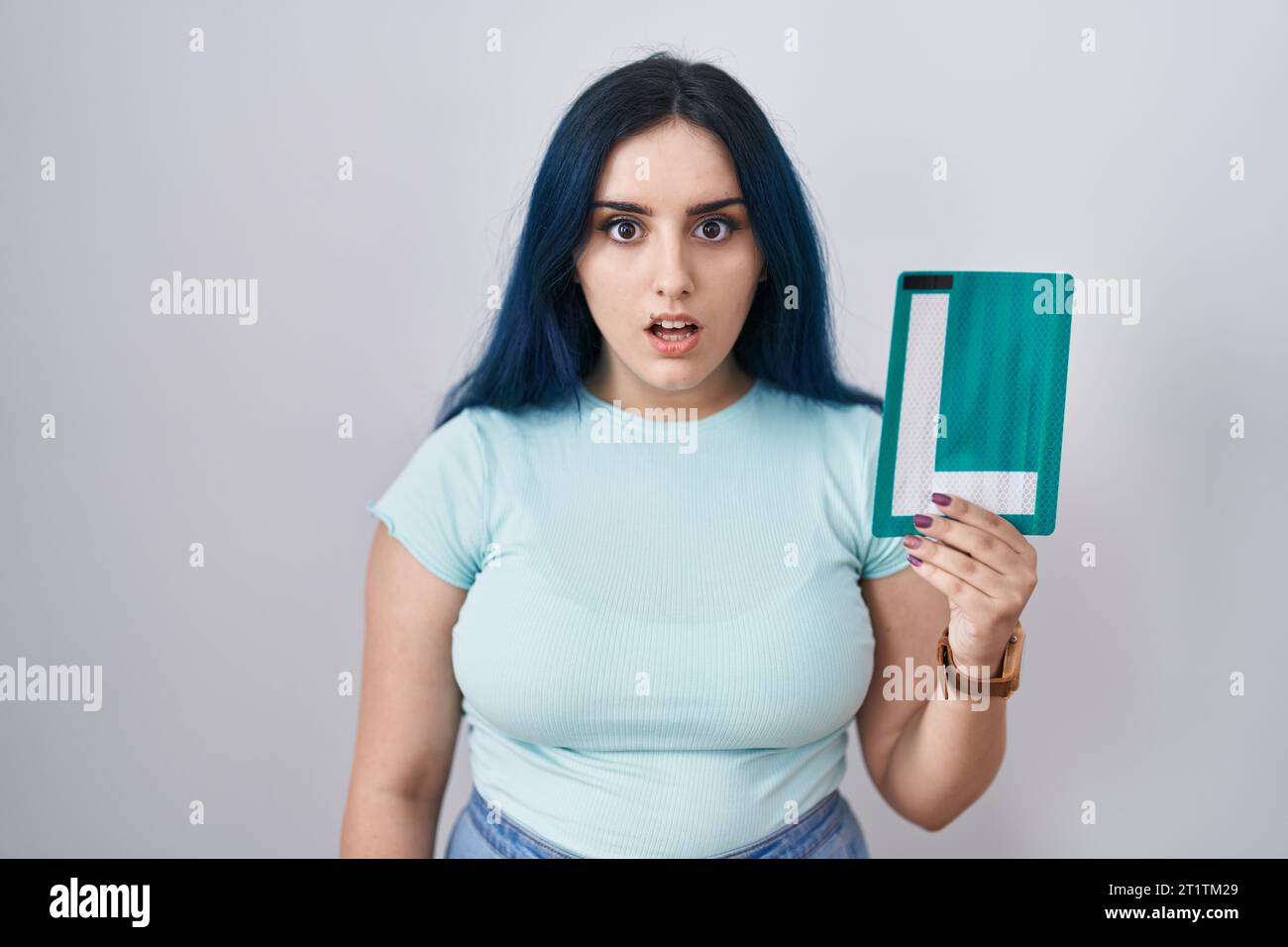 Young modern girl with blue hair holding l sign for new driver scared ...