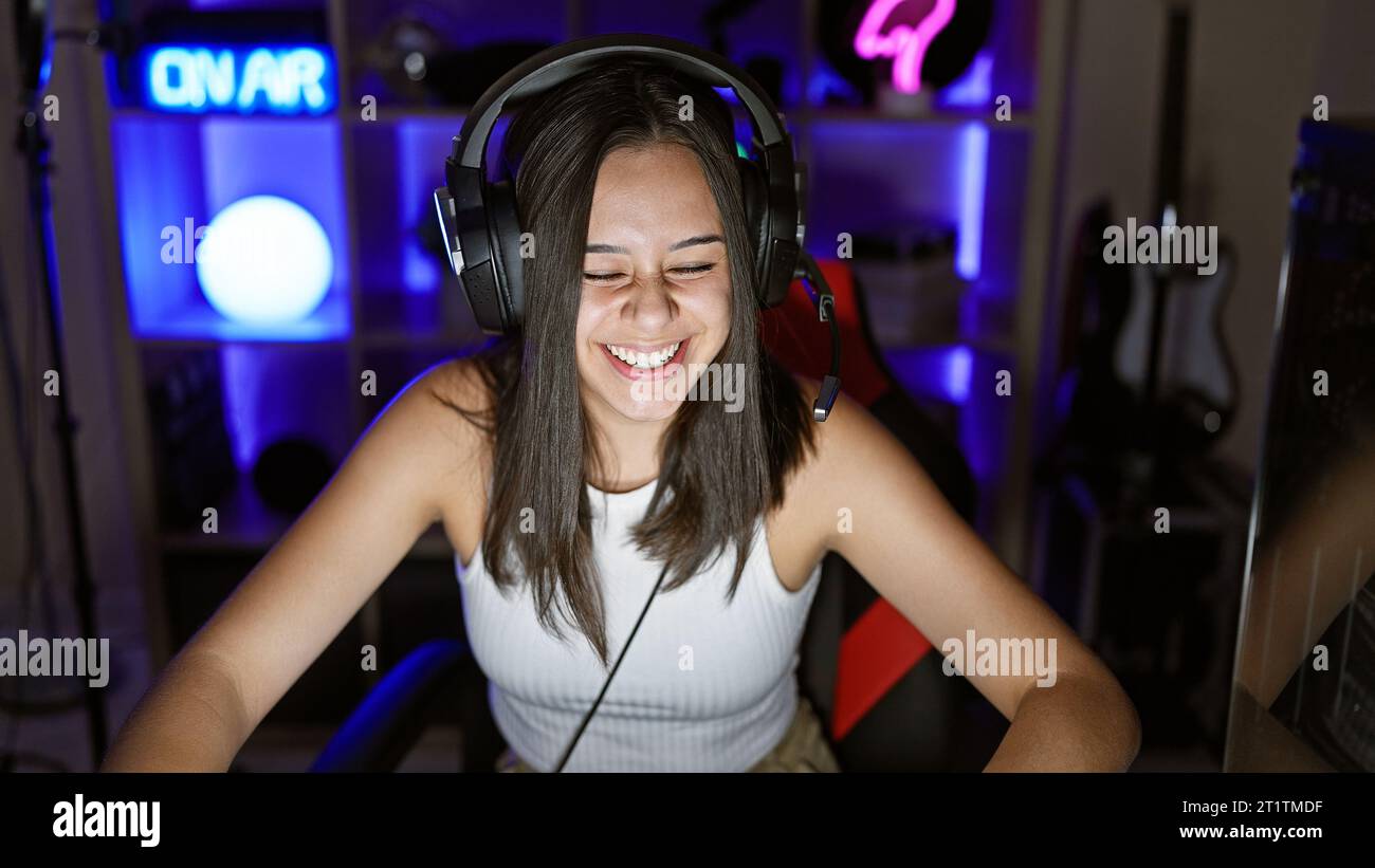 Young beautiful hispanic woman streamer playing video game using ...