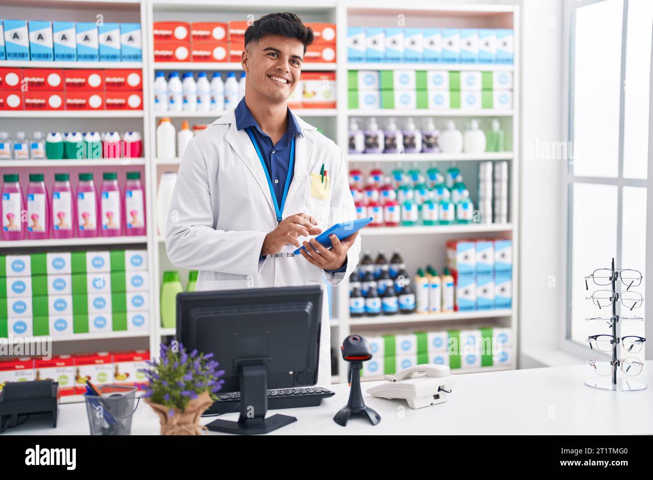 Young hispanic man pharmacist using touchpad working at pharmacy Stock ...