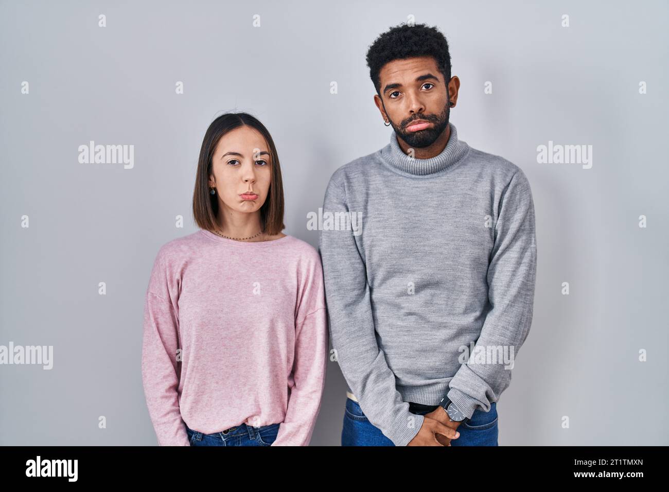 Young hispanic couple standing together depressed and worry for ...