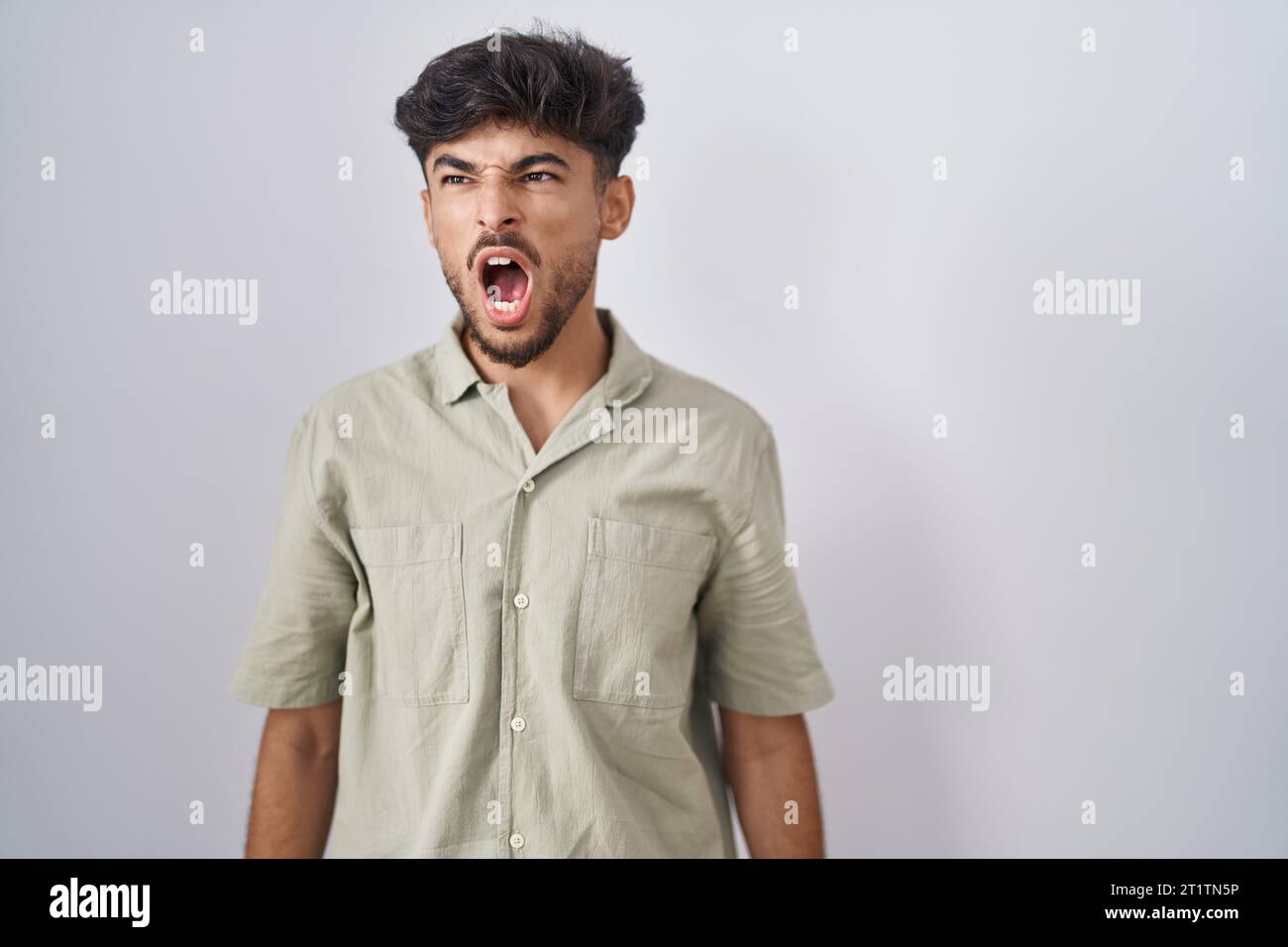Arab man with beard standing over white background angry and mad ...