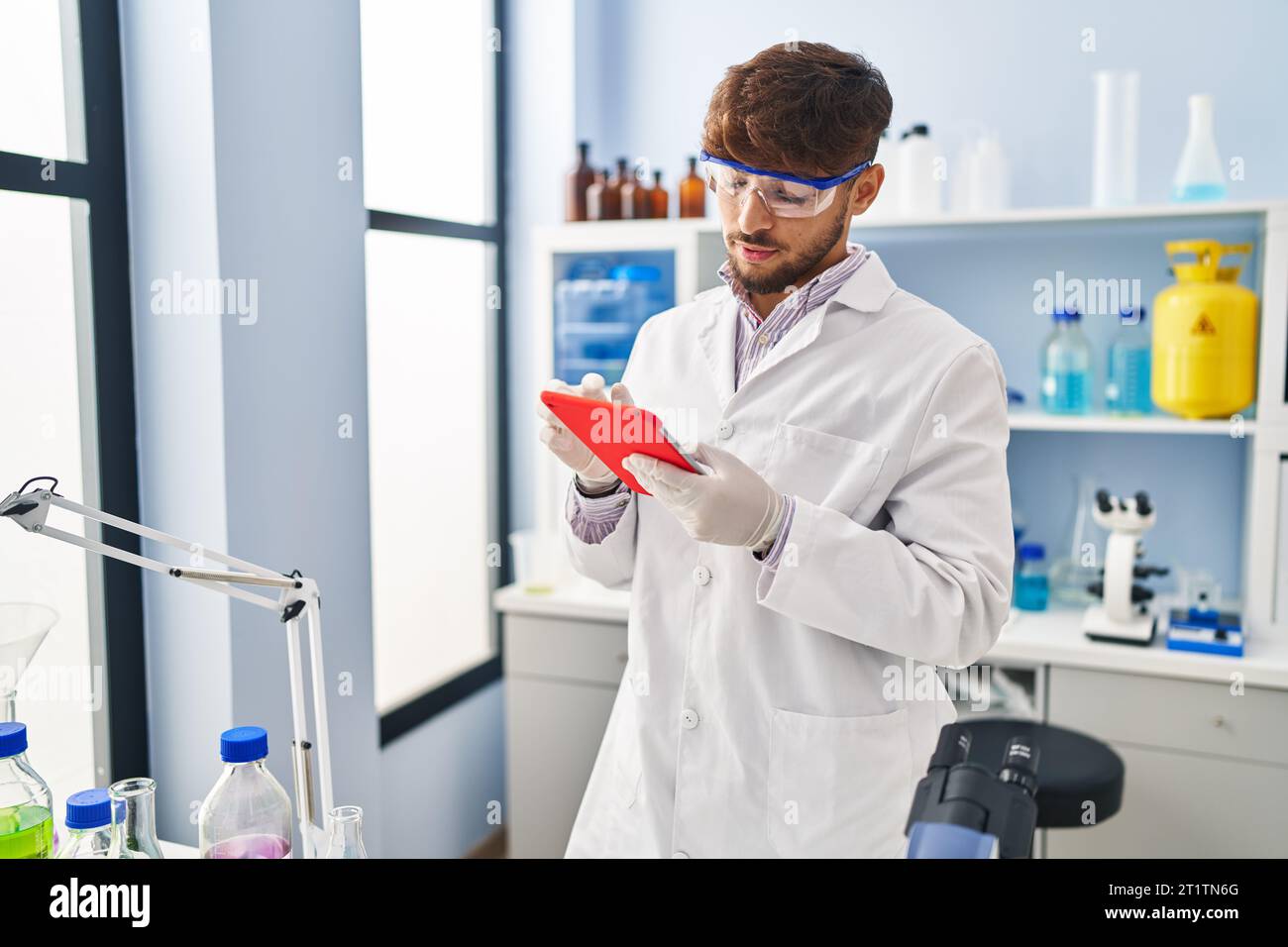Young arab man scientist using touchpad working at laboratory Stock Photo - Alamy